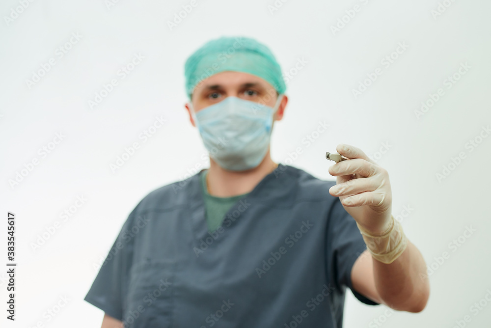 A photo of a surgeon in scrubs with a focus on a scalpel in a hospital ...