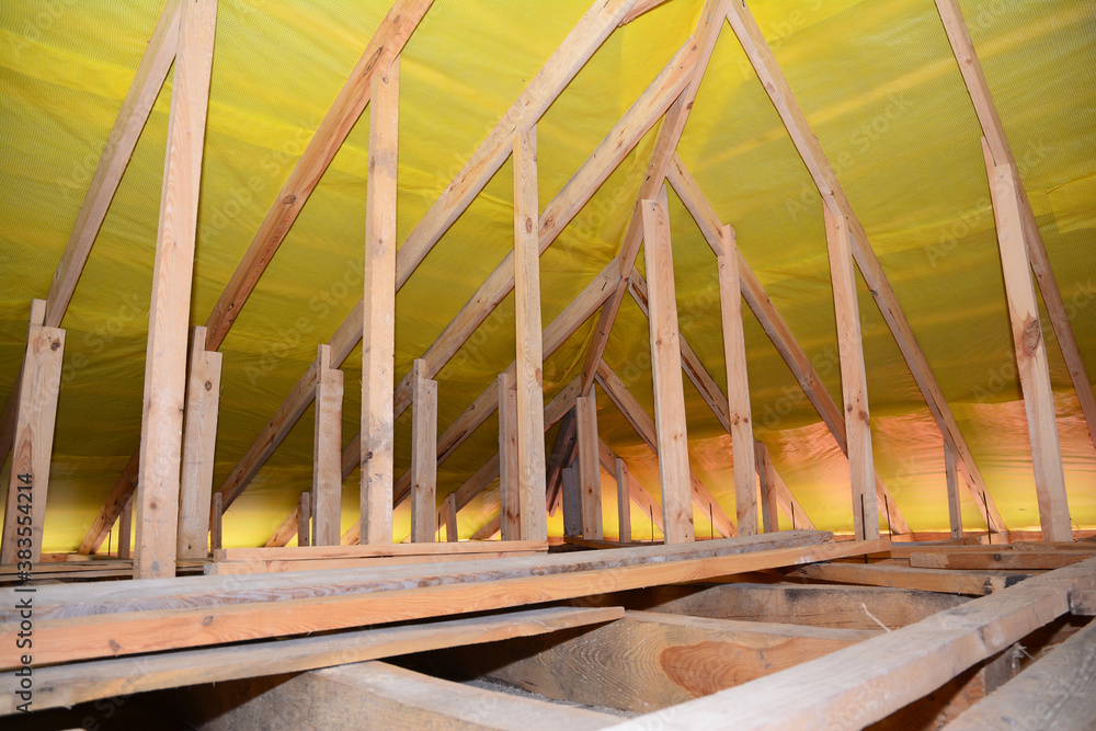 A view on unfinished attic from inside the house with a close-up on ...