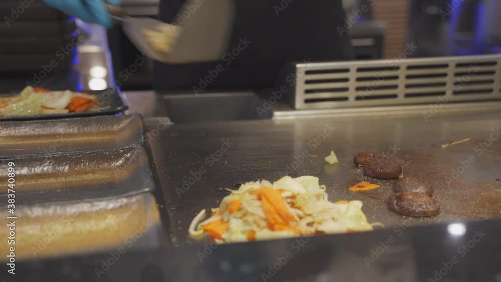 The scene of a Japanese chef making teppanyaki. Teppanyaki is a ...