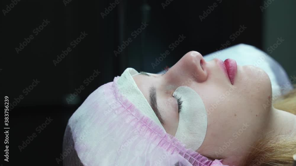 The work of an eyelash extension master. Lash Maker and a young girl at ...