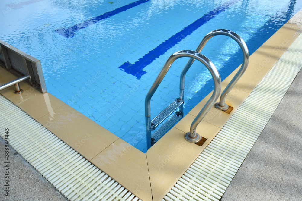 Swimming pool. Grab bars ladder made from stainless steel and beautiful ...