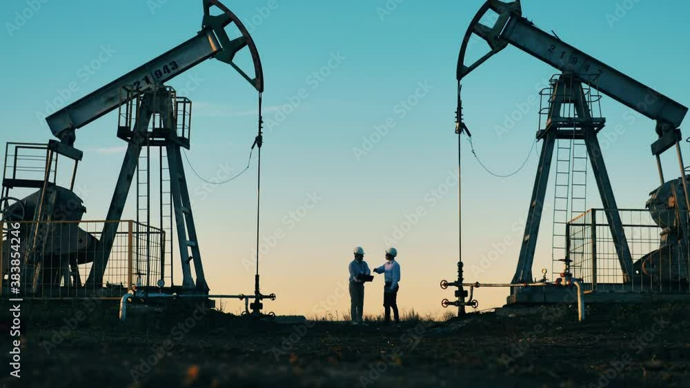 Video Stock Technicians are talking between two oil pumping units. Oil ...