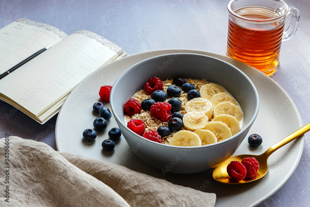 Side view of a healthy breakfast with oatmeal in a bowl, banana slices ...