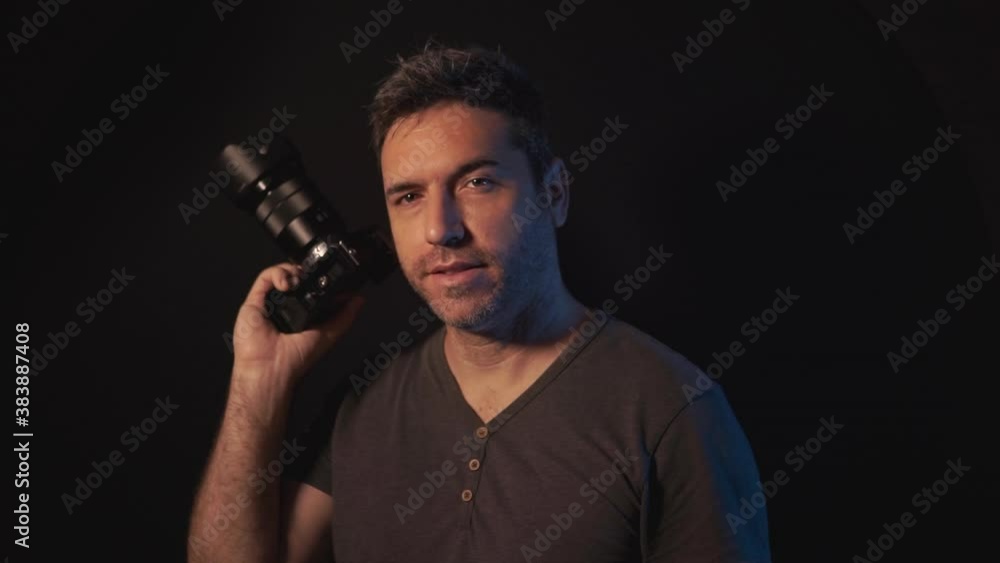 Portrait of a male professional photographer holding a dslr mirrorless ...