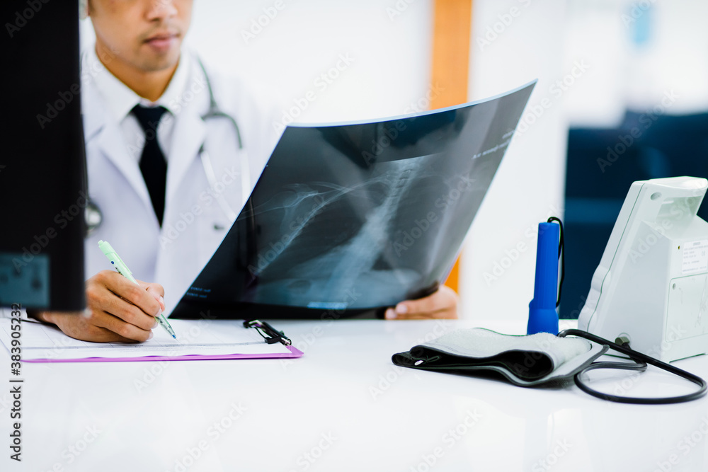 Radiology doctor examining at chest x ray film of patient at health ...