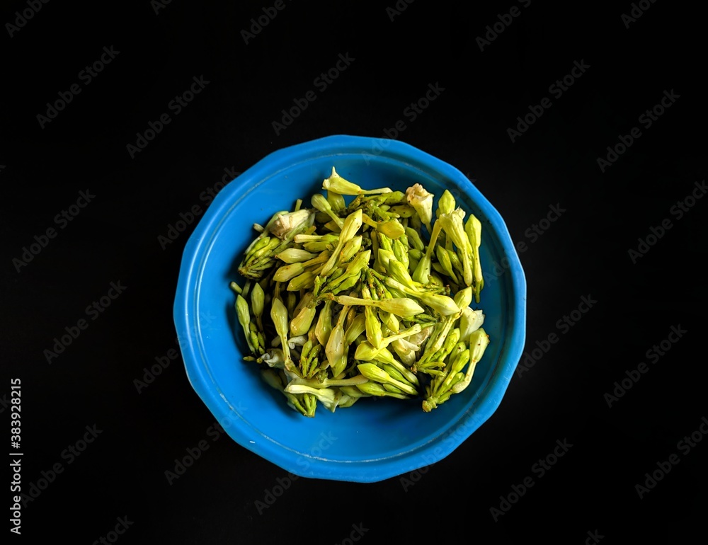 Fernaldia pandurata loroco flower on a plate on black background ...