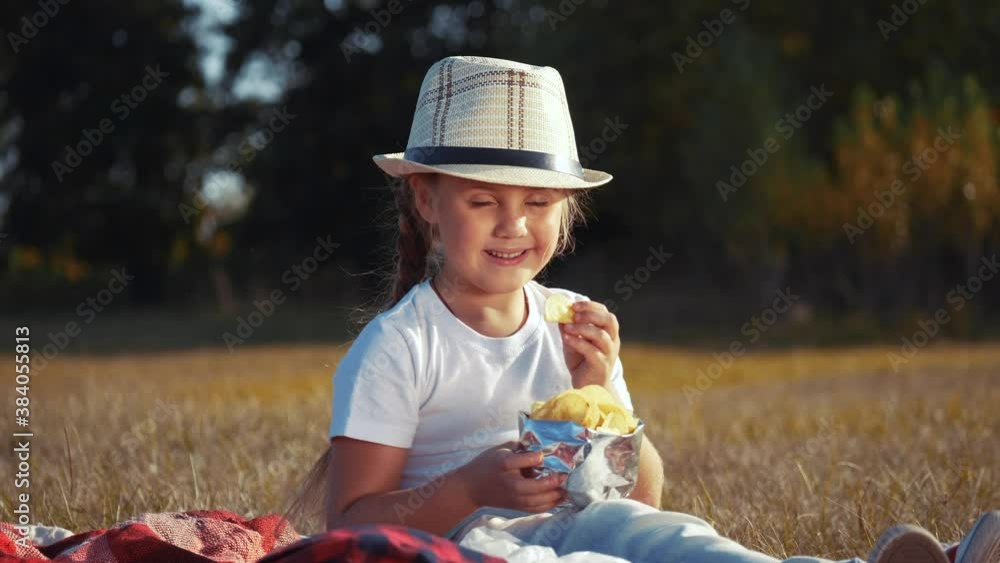 child eating chips close-up face. kid resting in the park eating chips ...