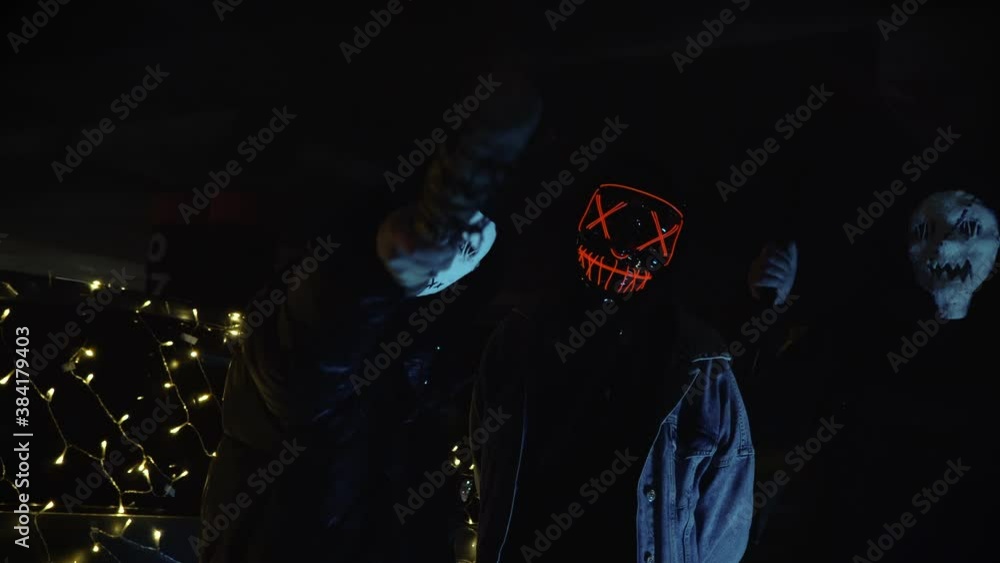 People with luminous purge masks are holding a baseball bat and katana ...