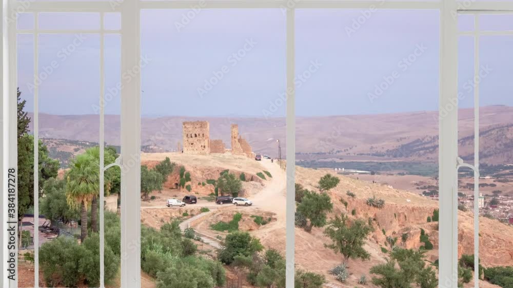Fes or Fez landscape as seen from a white window while birds are flying ...