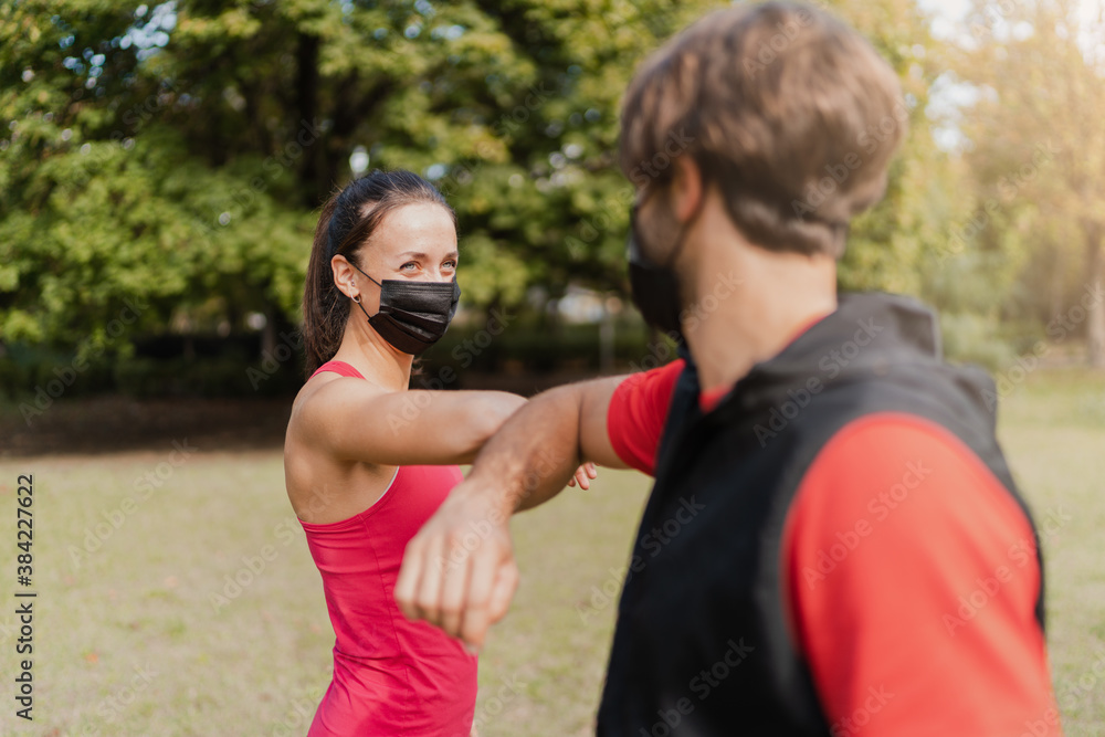 Young happy couple friends at the park bump their elbows instead of ...