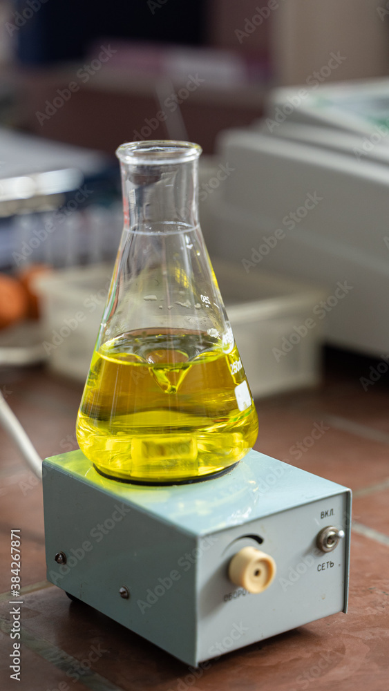 Erlenmeyer flask with yellow liquid inside on a measurement machine in ...