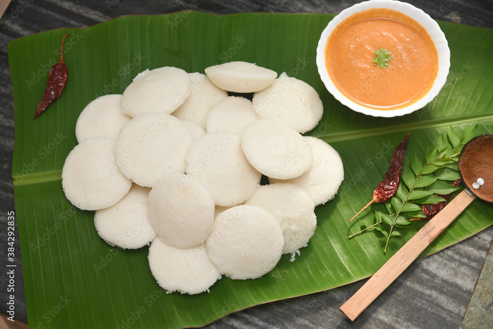 Indian idly served on traditional banana leaf vegetarian food. Lots of ...
