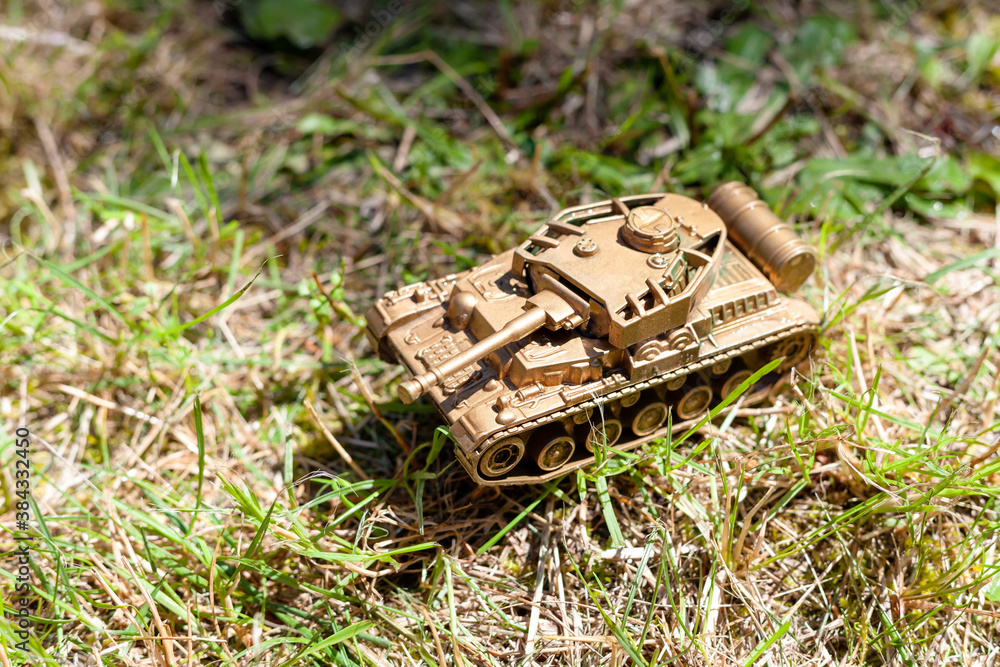Gold tank plastic toy laying on the ground. Golden tank, military ...