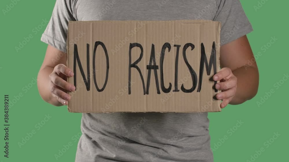 Man holds in front of him a poster from a cardboard box with the words ...