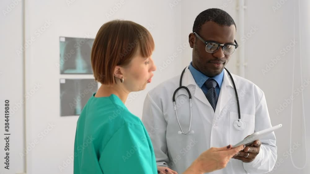 Vidéo Stock Two young doctors are talking about working and using ...