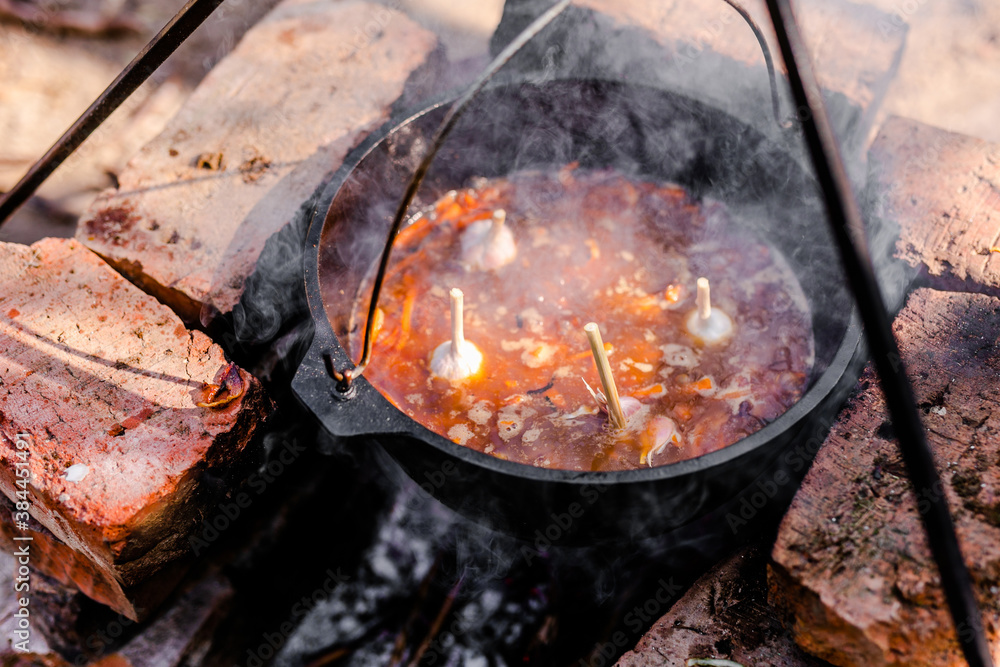 Preparation of raditional armenian pilaf in a cauldron on an open fire ...