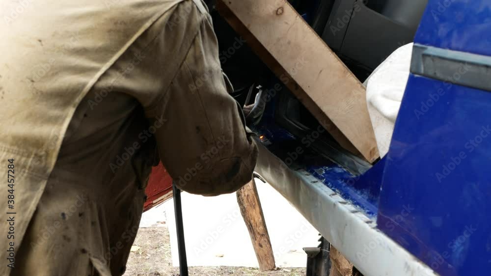 Auto body repair on sill panel of car using welding, Mechanic welds the ...