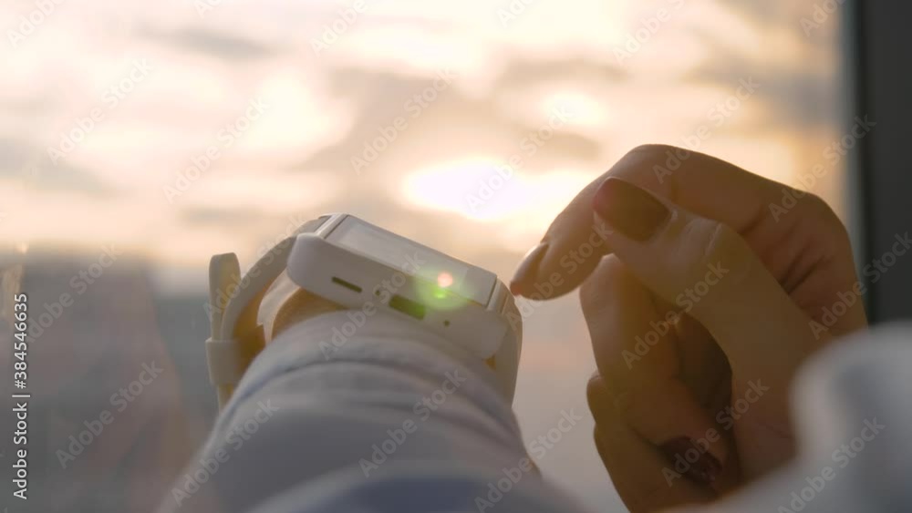 Close up: woman hand using wearable white smartwatch device against ...