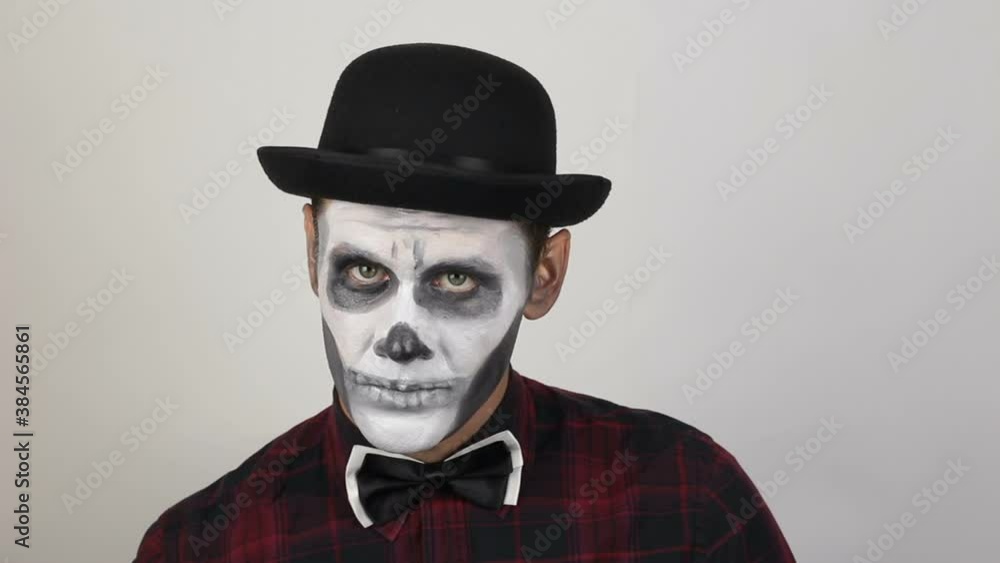 A hideous man in clown makeup raises his hat to greet his victim. The ...