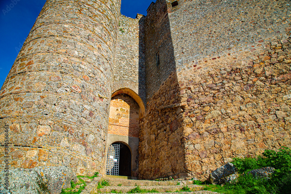 Entrada y puerta principal de castillo entre gran muro y torre redonda ...