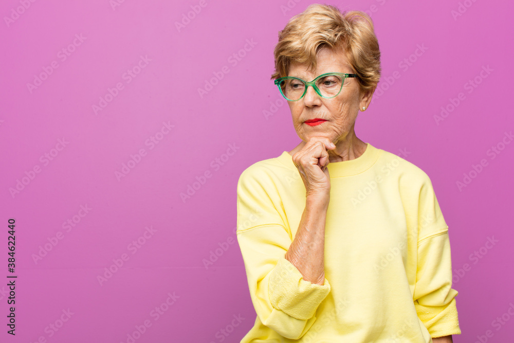 old pretty woman thinking, feeling doubtful and confused, with ...