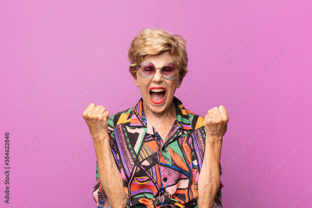 old pretty woman shouting aggressively with an angry expression or with ...