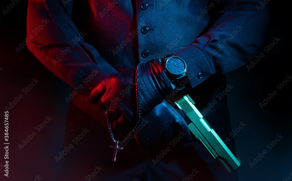 Photo of a male mafia criminal killer in suit and leather gloves ...