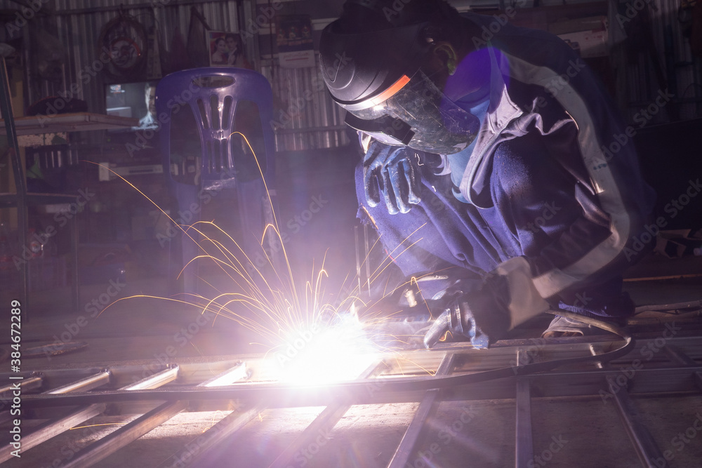 The welder is welding the parts of the iron door. The person working on ...