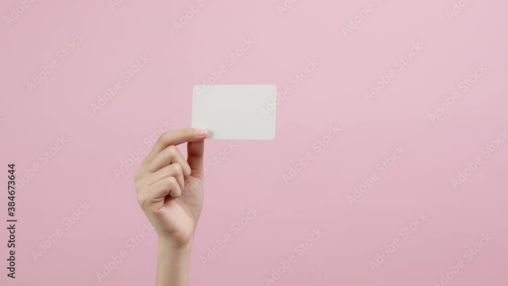 Hand holding a white paper label on the pink background for ...