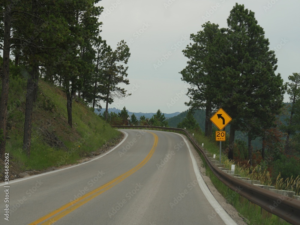 Roadside signs with speed direction along a sharp curve in the road at ...