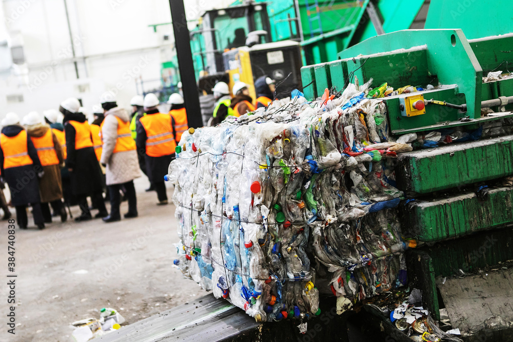 Briquettes of plastic garbage on the background of the workers of the ...