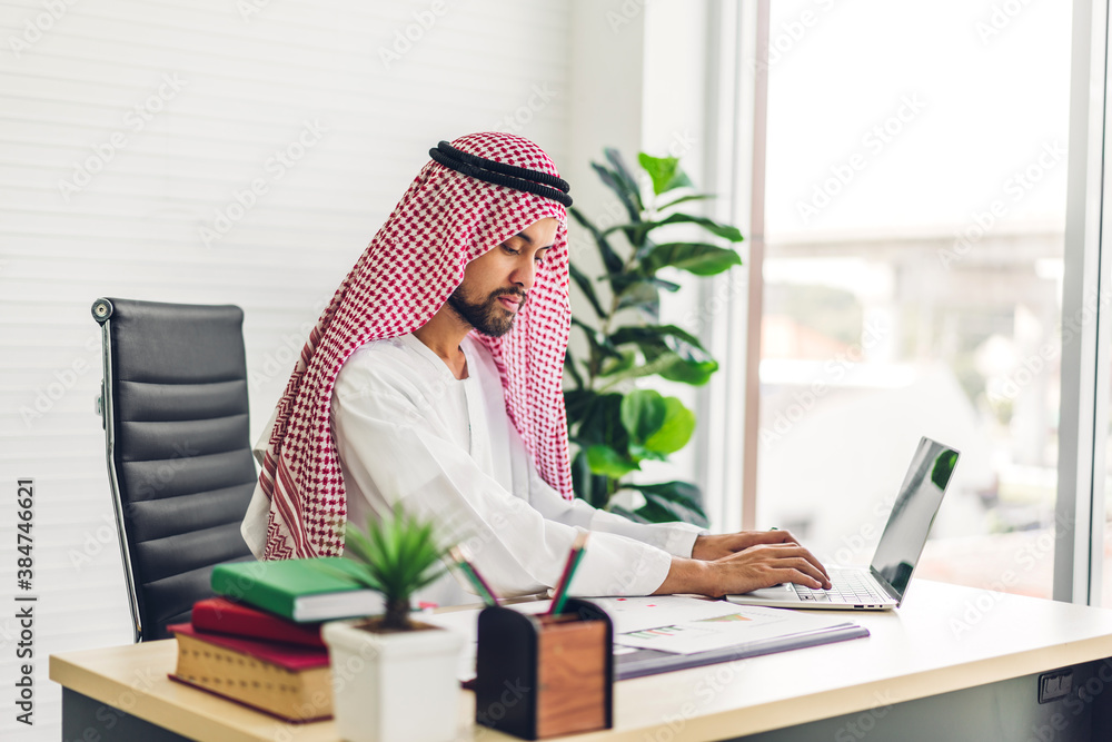 Confident arab businessman working and looking at technology of laptop ...