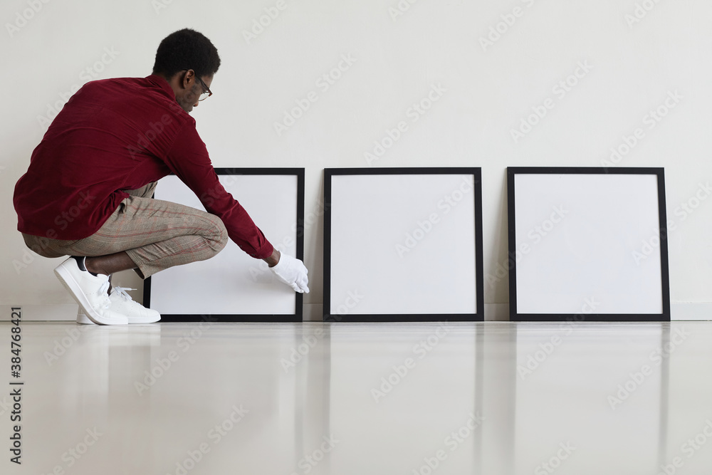 Full length portrait of African-American man setting up blank black ...