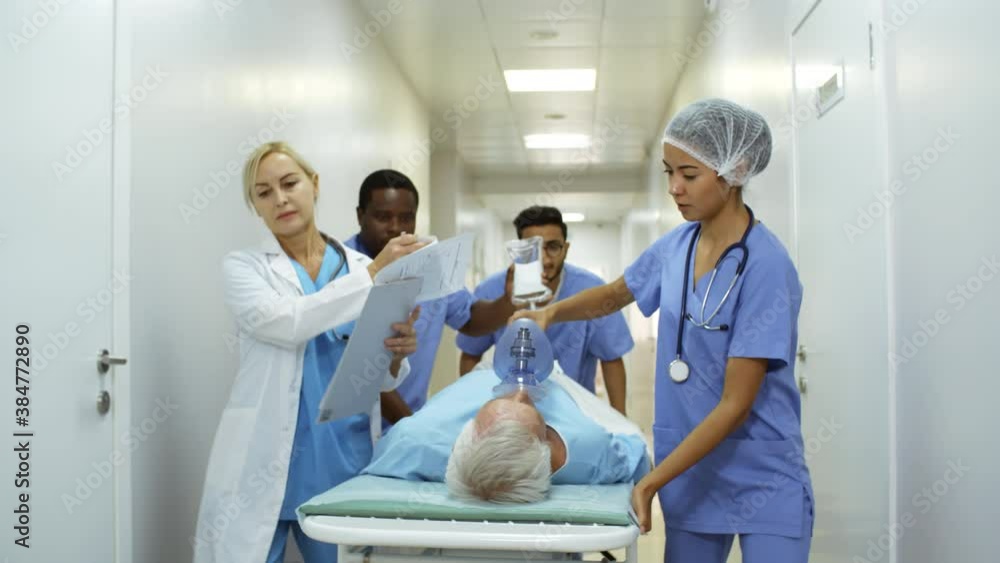Dolly shot of multi-ethnic group of ER nurses administering oxygen and ...