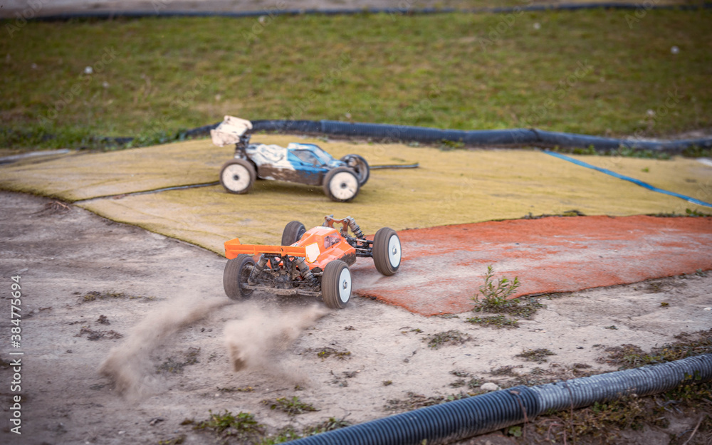 Orange RC buggy accelerating from a corner on an outdoor track Stock ...