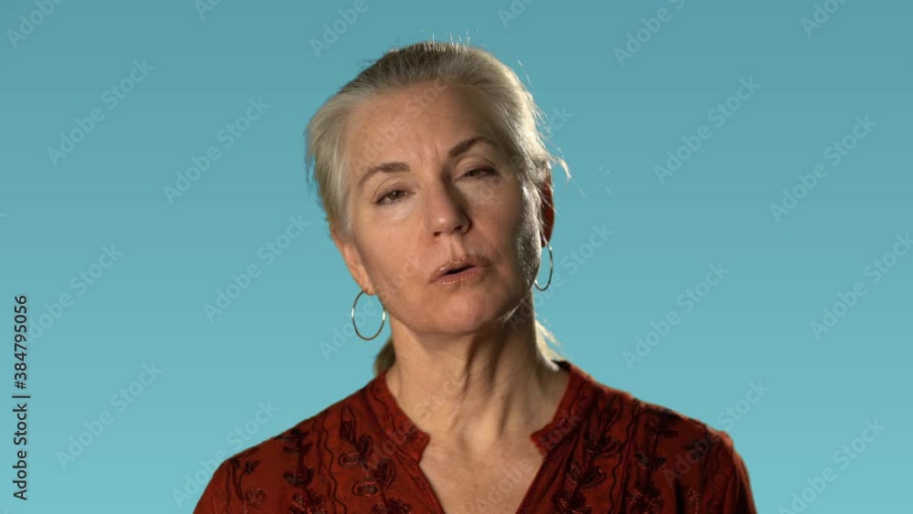 Woman sneezes into medical face mask and looks embarrassed disgusted in ...