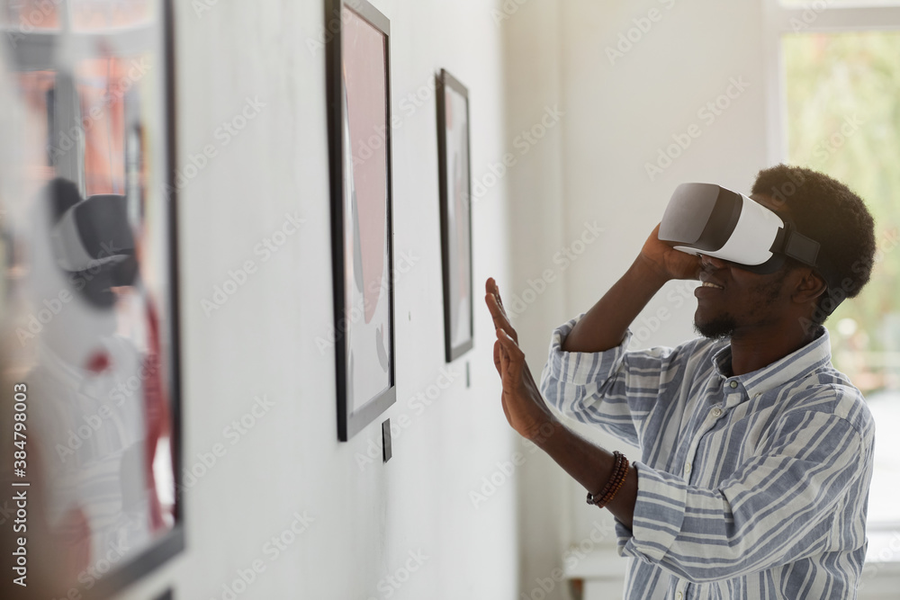 Side view portrait of smiling African-American man wearing VR gear ...