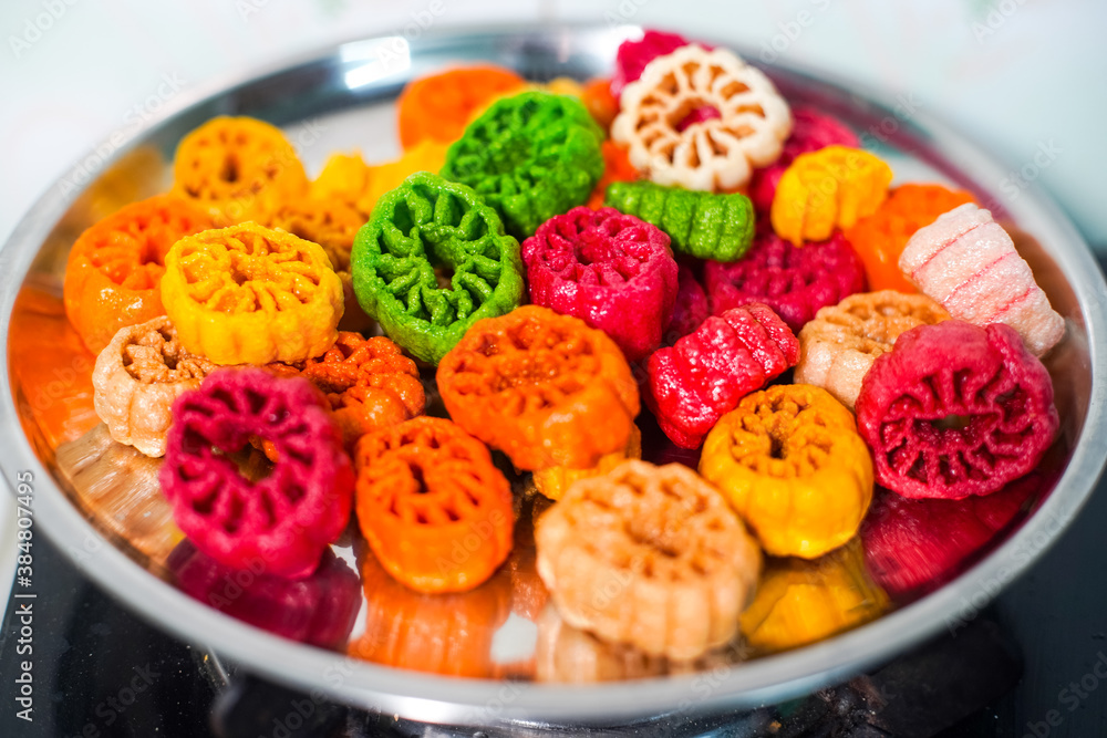 shot of colorful Fryums being deep fried in hot oil bubbling and ...