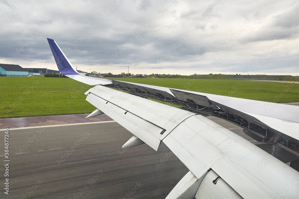 Airplane wing with flaps and spoilers fully extended to slow down the ...