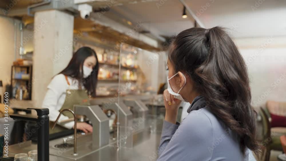Female customer dining in restaurant. Waitress wear mask making coffee ...