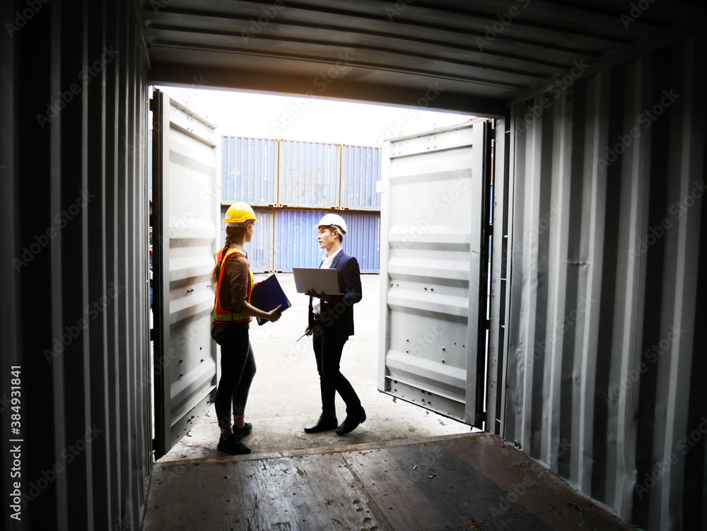 Young Engineers standing in the shipping yard tracking the cargo ...