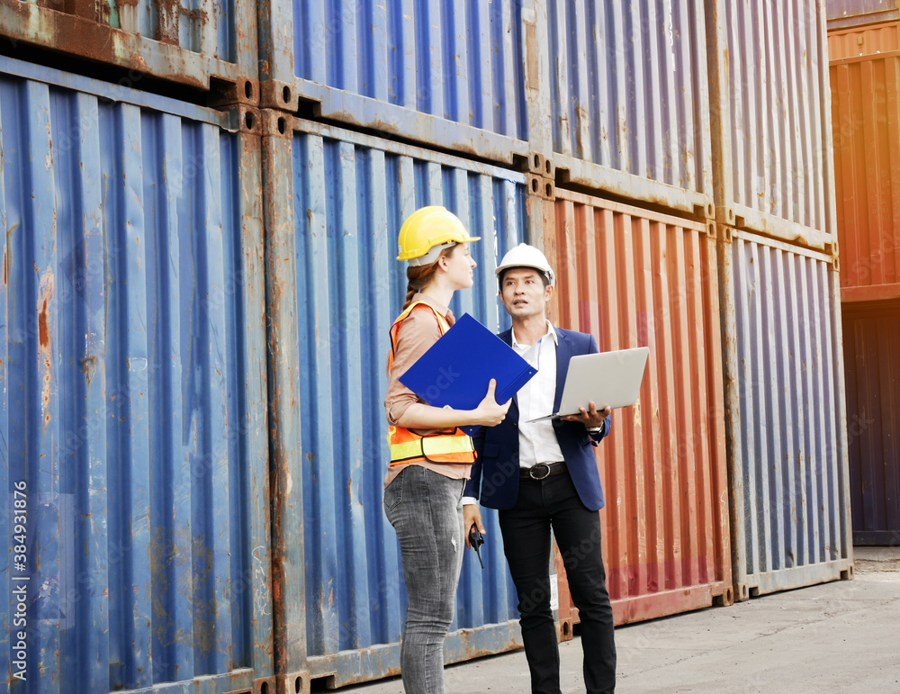 Young Engineers standing in the shipping yard tracking the cargo ...