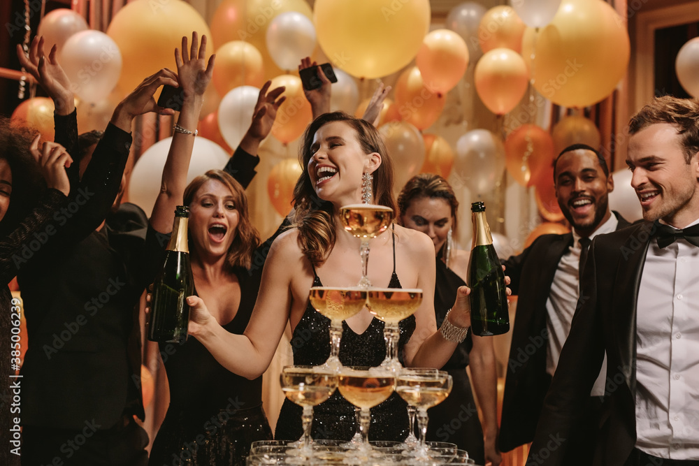 Pyramid of champagne with people dancing around in party Stock Photo ...