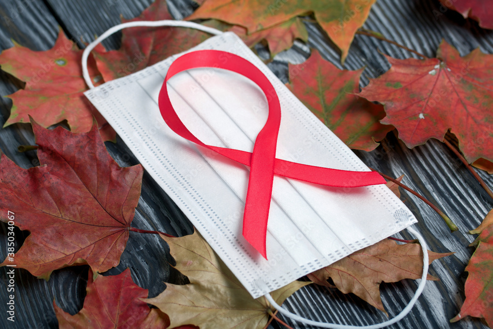 Red Ribbon Symbol for World AIDS Day. Lies on a medical mask. Around ...