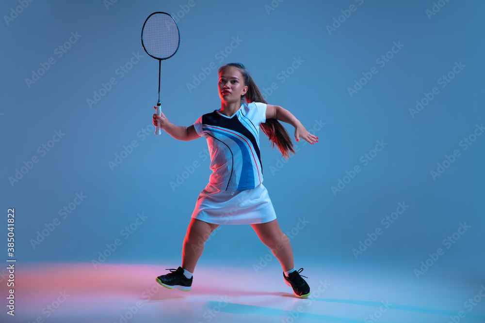 Energy. Beautiful dwarf woman practicing in badminton isolated on blue ...