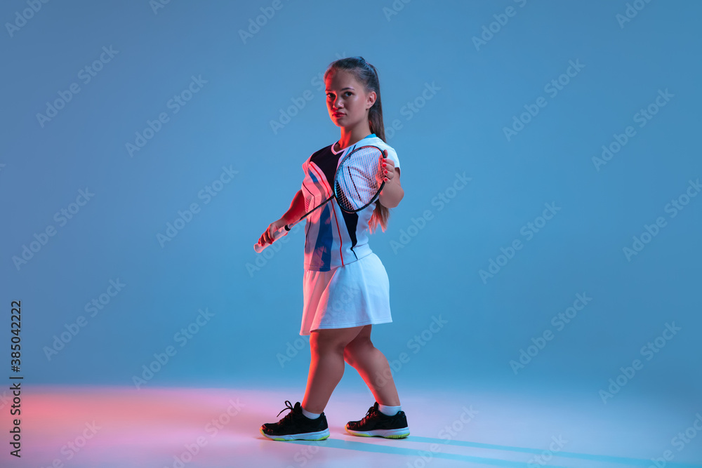 Energy. Beautiful dwarf woman practicing in badminton isolated on blue ...