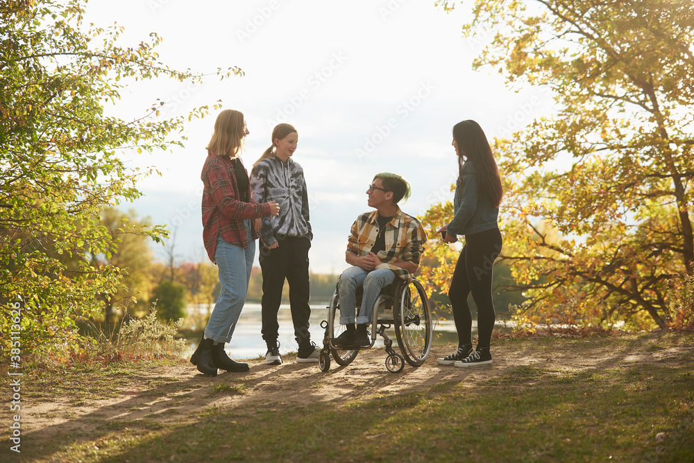 Disabled teen in a wheelchair hanging out with multi ethnic group of ...