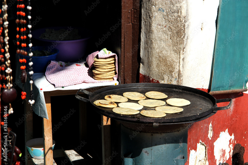 view of female indigenous hand making tortillas on comal, traditional ...