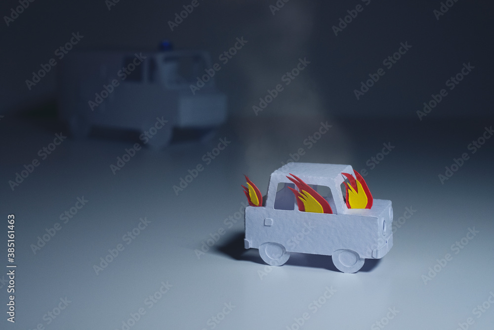 The Accident, a paper craft image of a burning paper car with colourful ...
