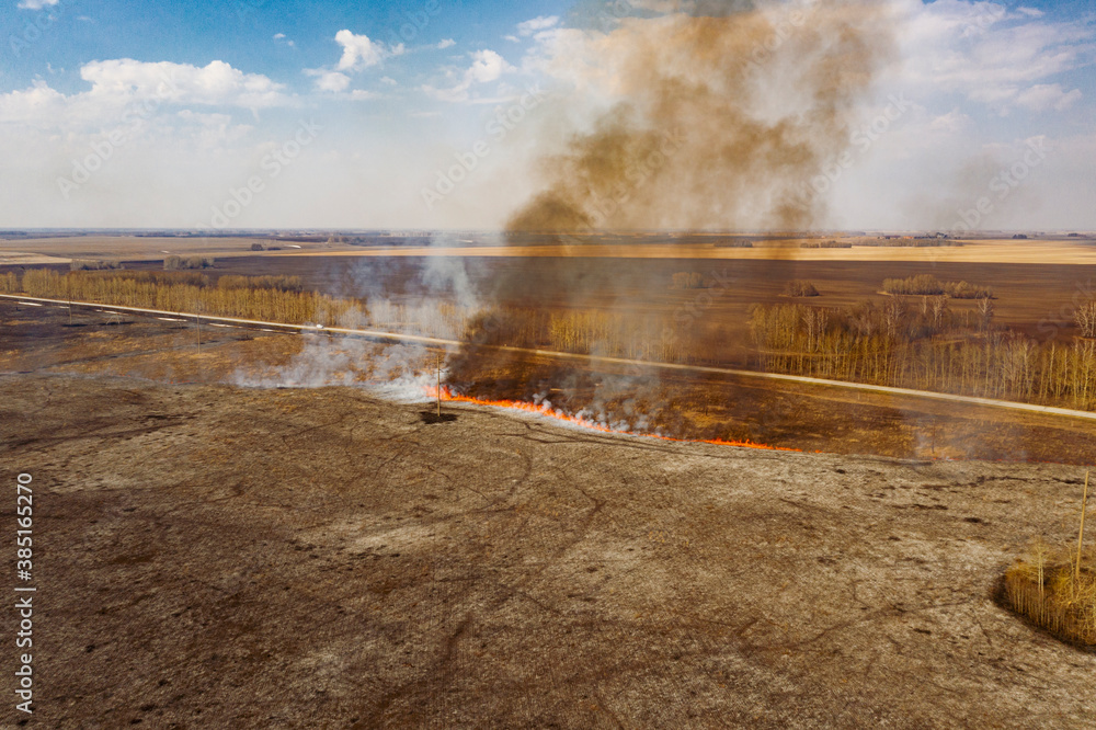 Dangerous fire with gray and brown smoke in countryside in daytime ...